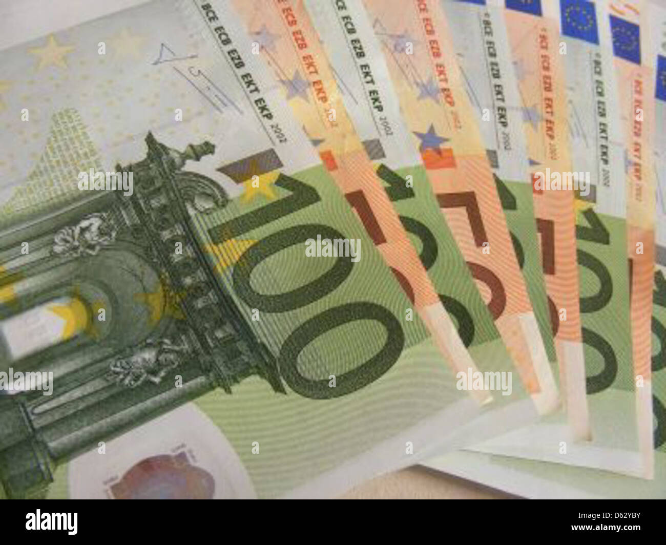 This image features various forms of currency, including 100 Euro notes ...
