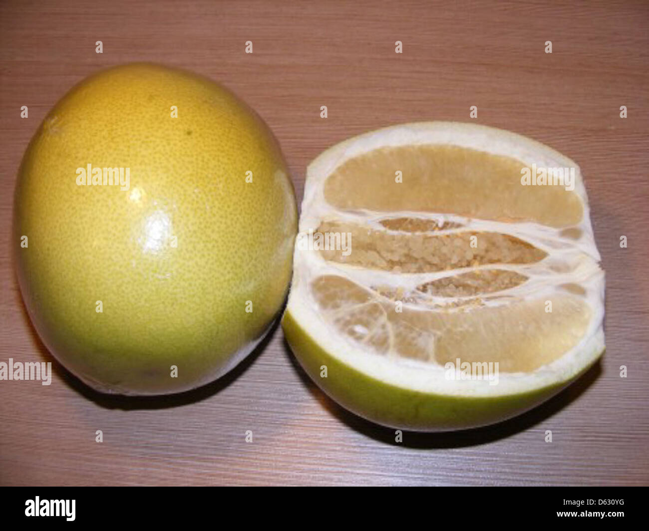 A fresh pomelo fruit, sliced in half to reveal its juicy, sweet ...
