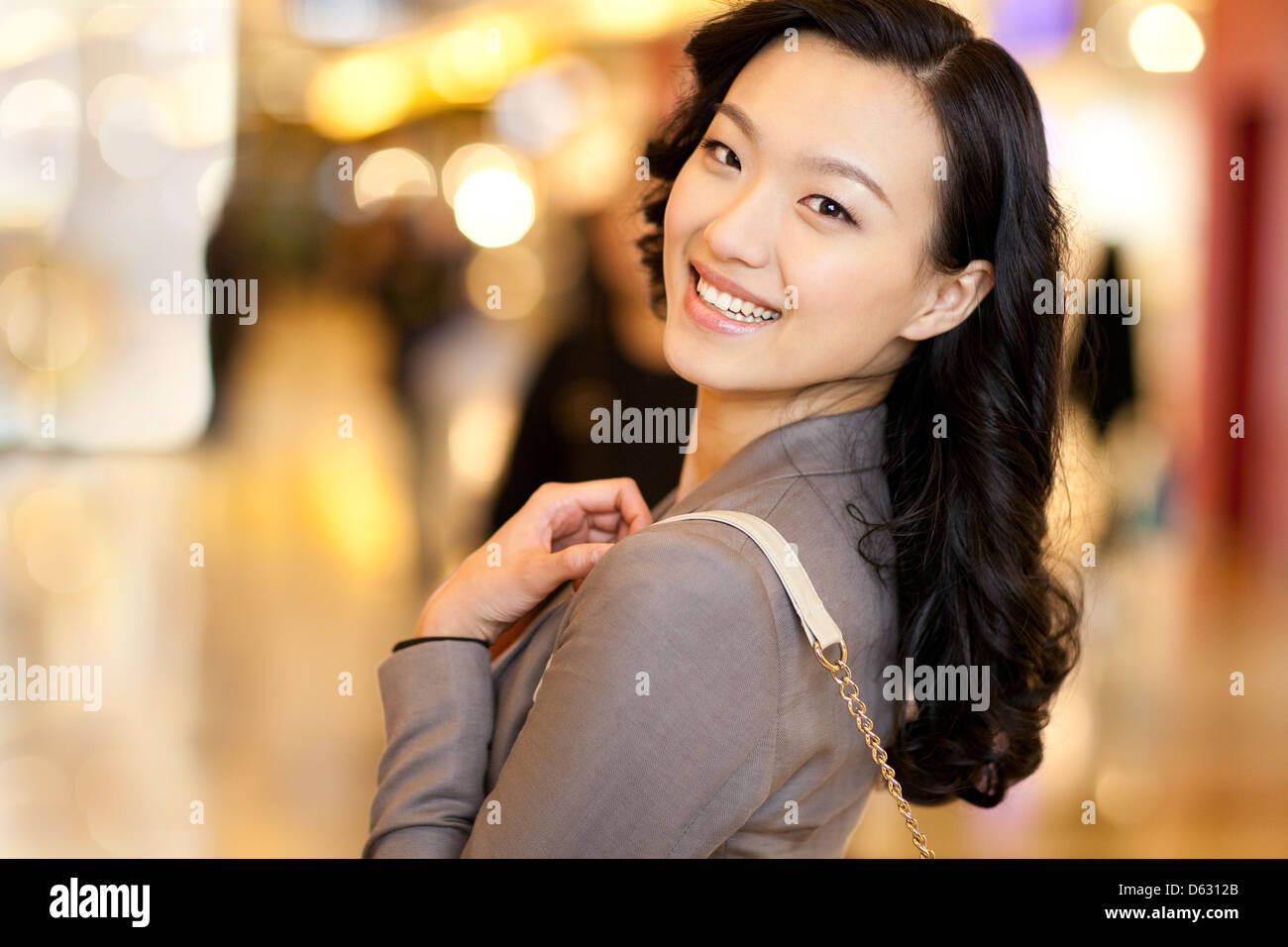 Elegant young woman looking over shoulder Stock Photo - Alamy
