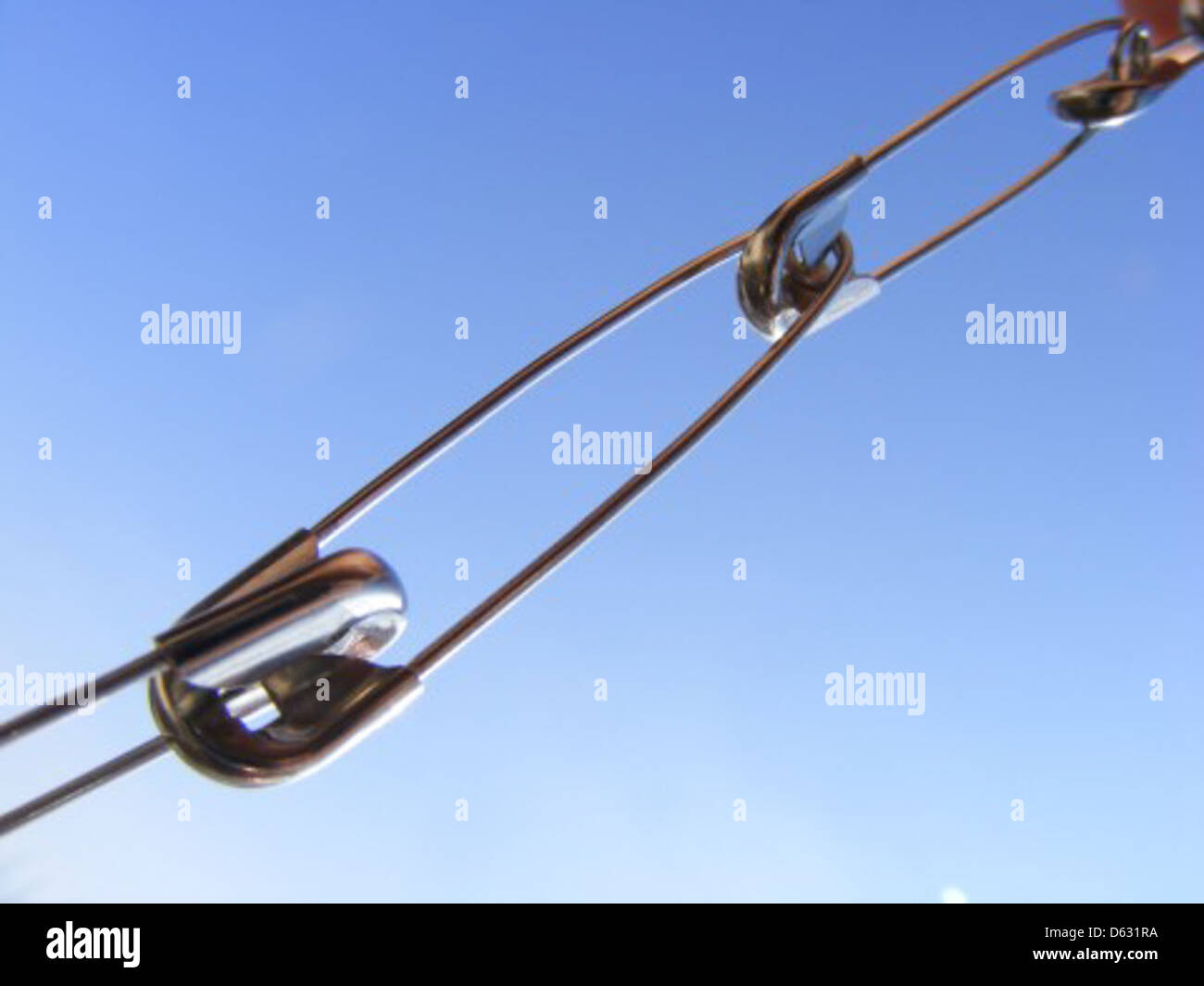 A close-up image of blue safety pins, commonly used for securing fabric ...