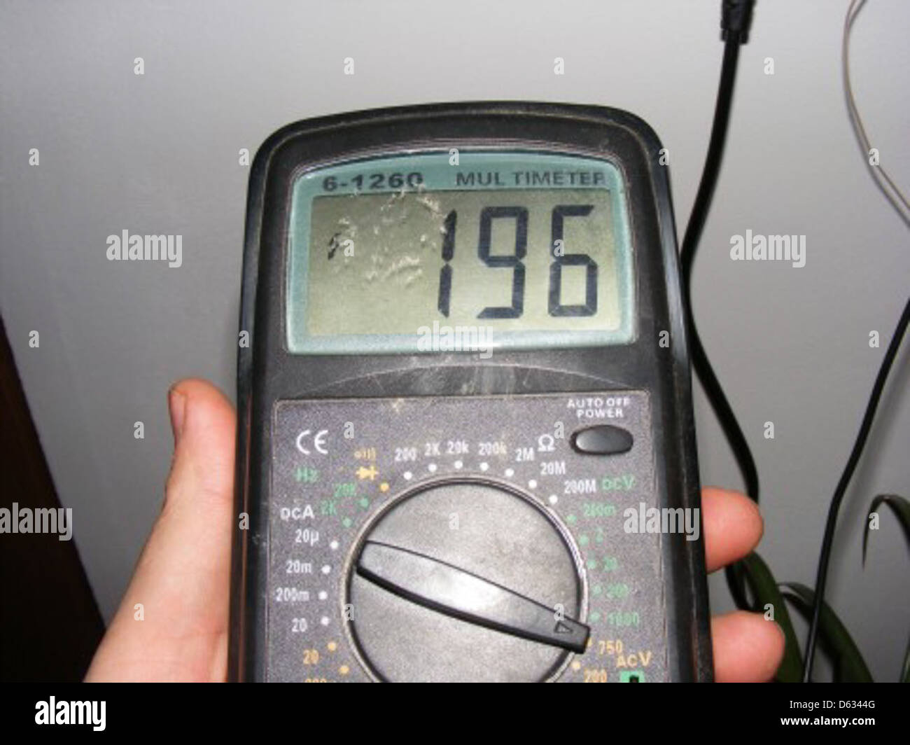 This image shows a digital multimeter being used for voltage testing ...
