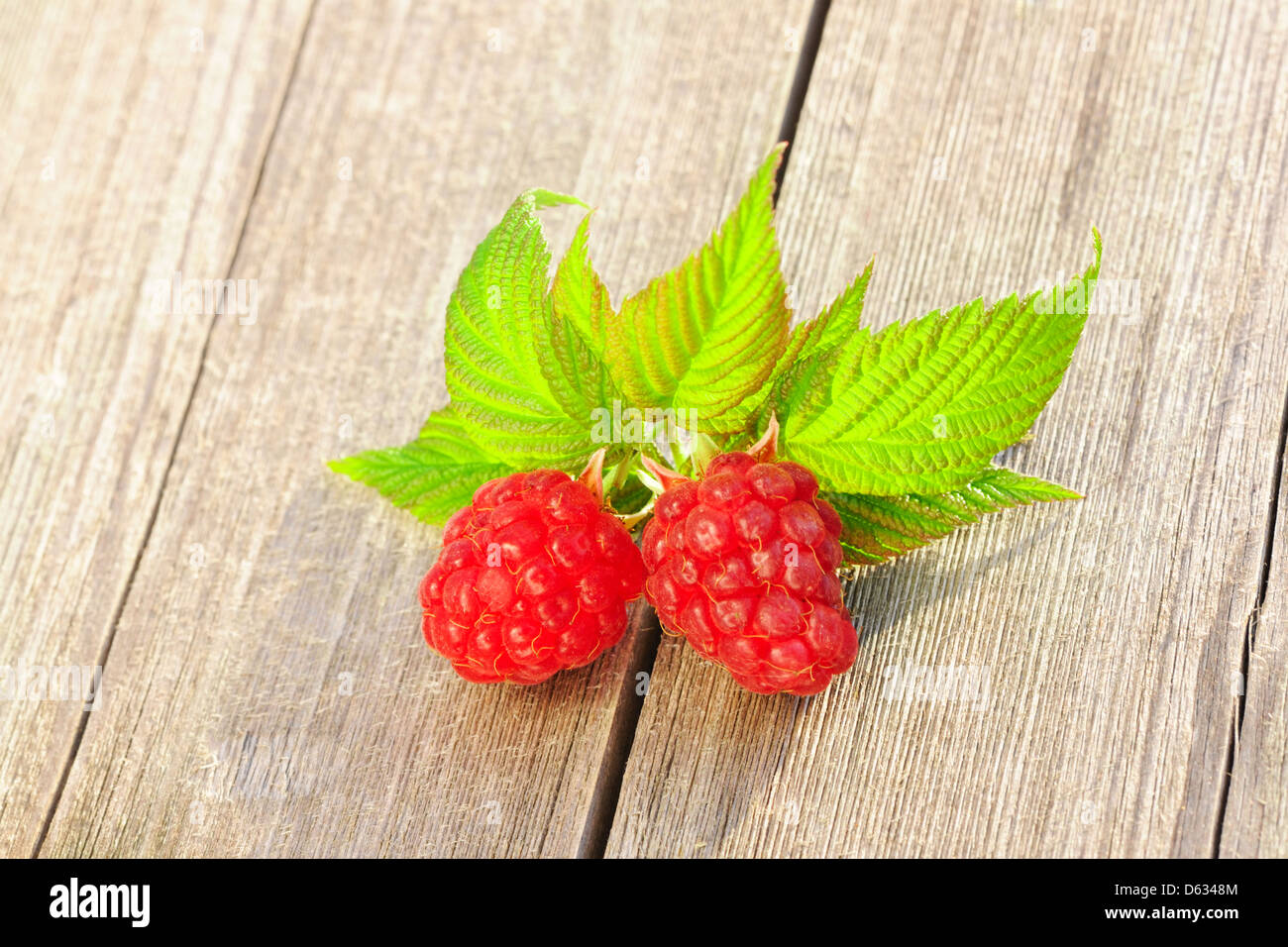 Raspberry on wooden table Stock Photo - Alamy