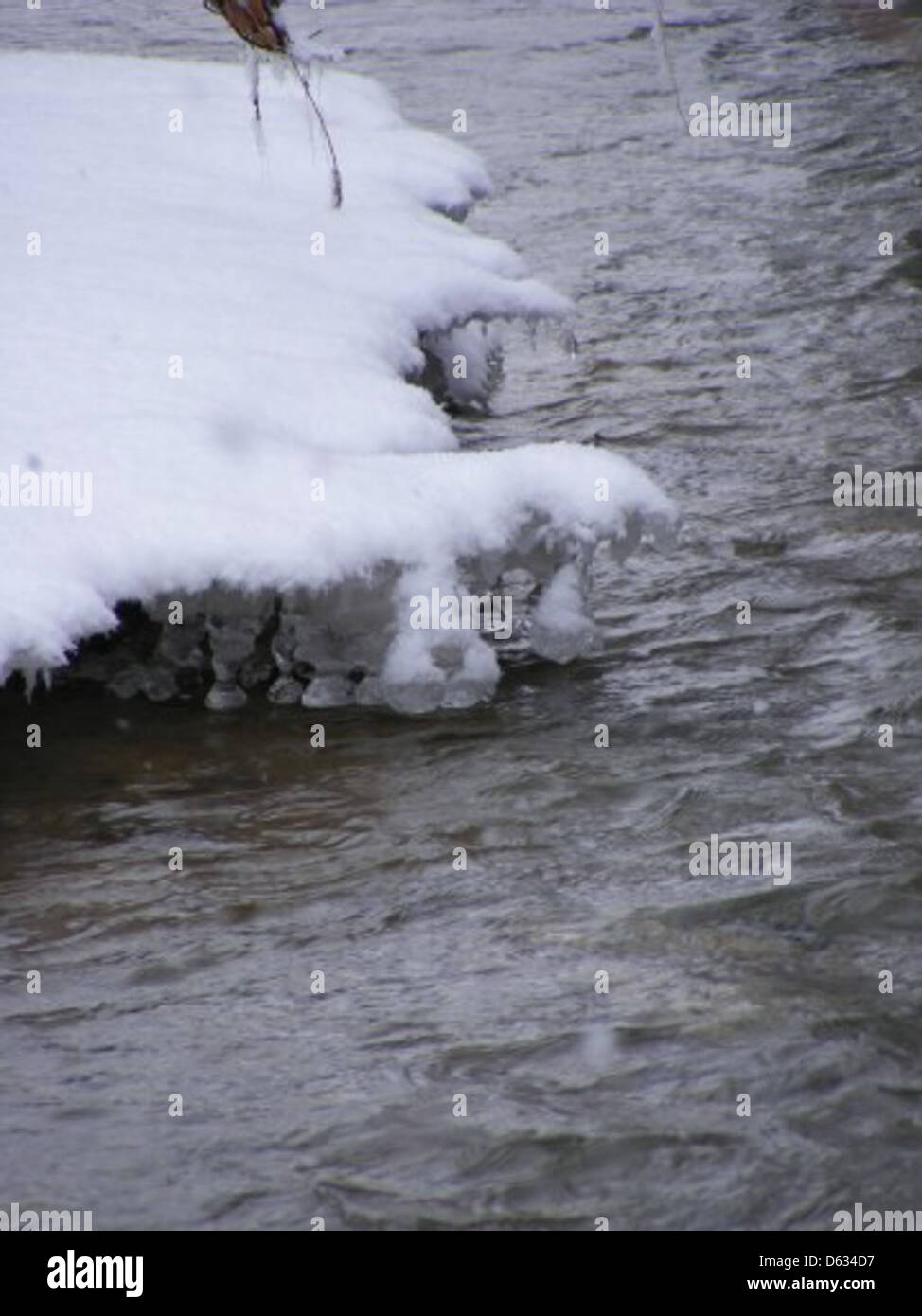 The image shows a frozen river during winter, with snow covering the ...