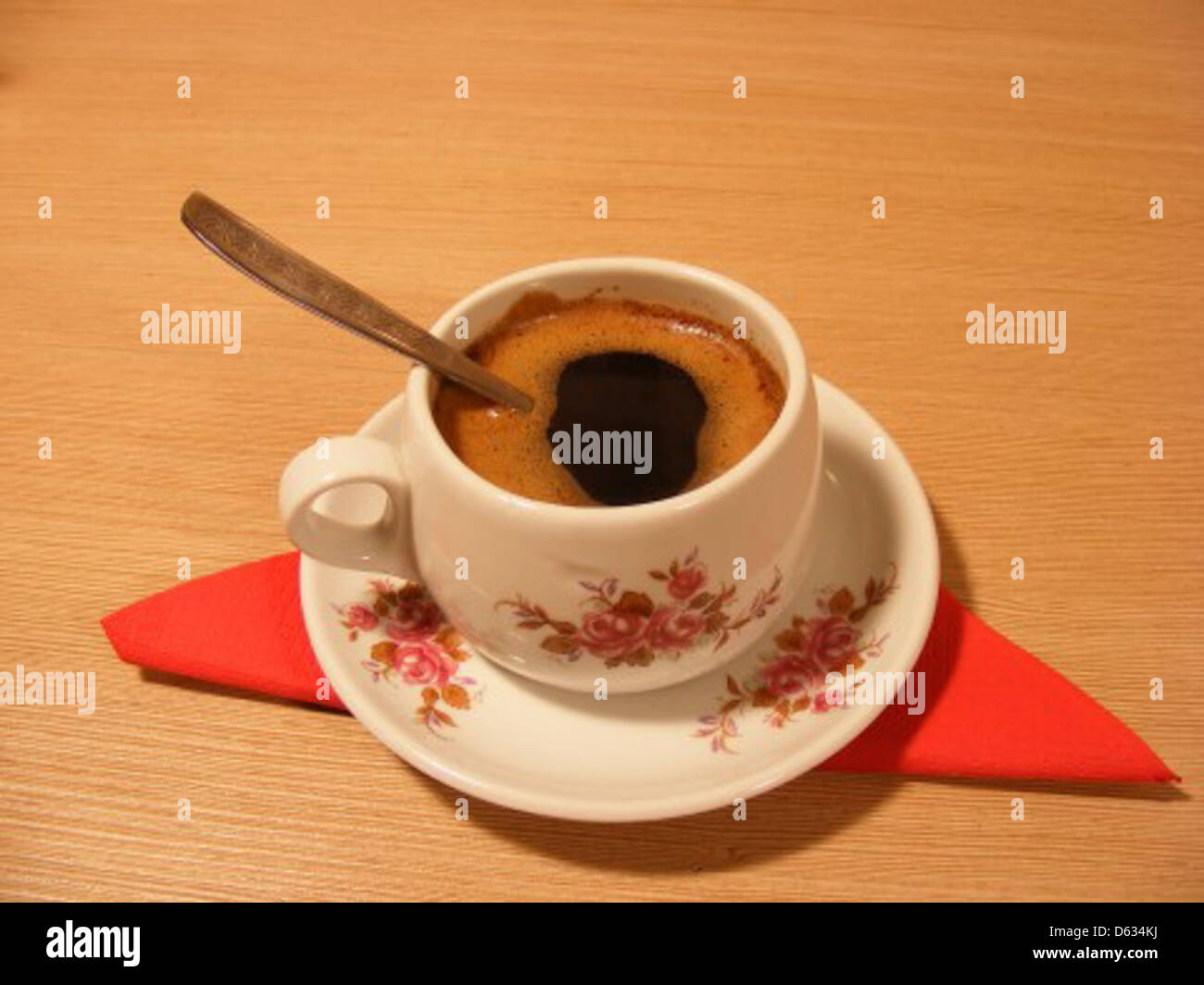 The image shows a red coffee cup on a napkin, accompanied by a sweet ...
