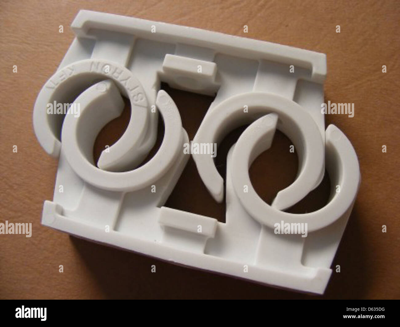 A double snap-on pipe clip fitting, made of durable plastic. These ...