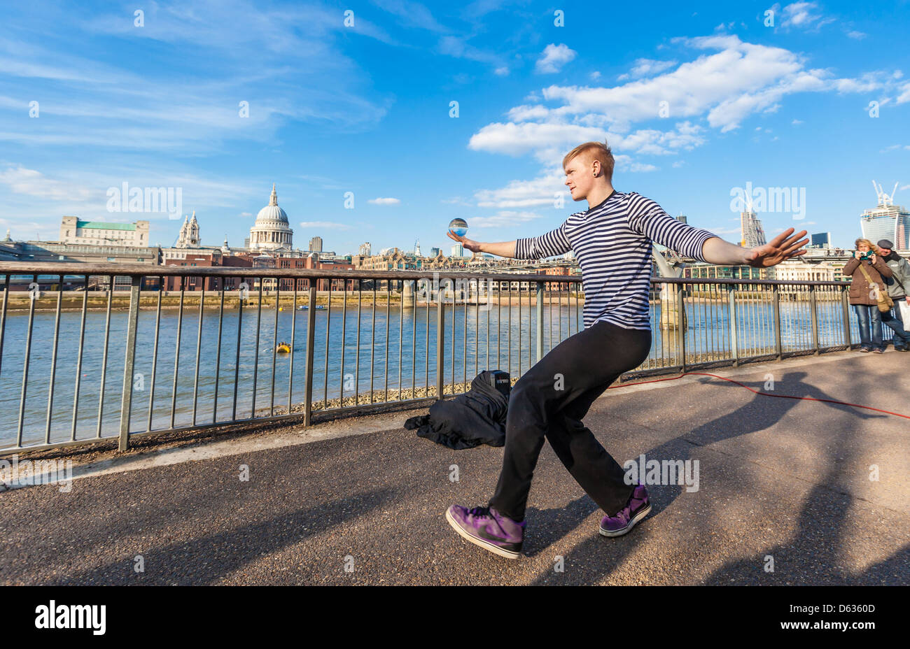Street performer juggling with a crystal ball on The River Thames ...