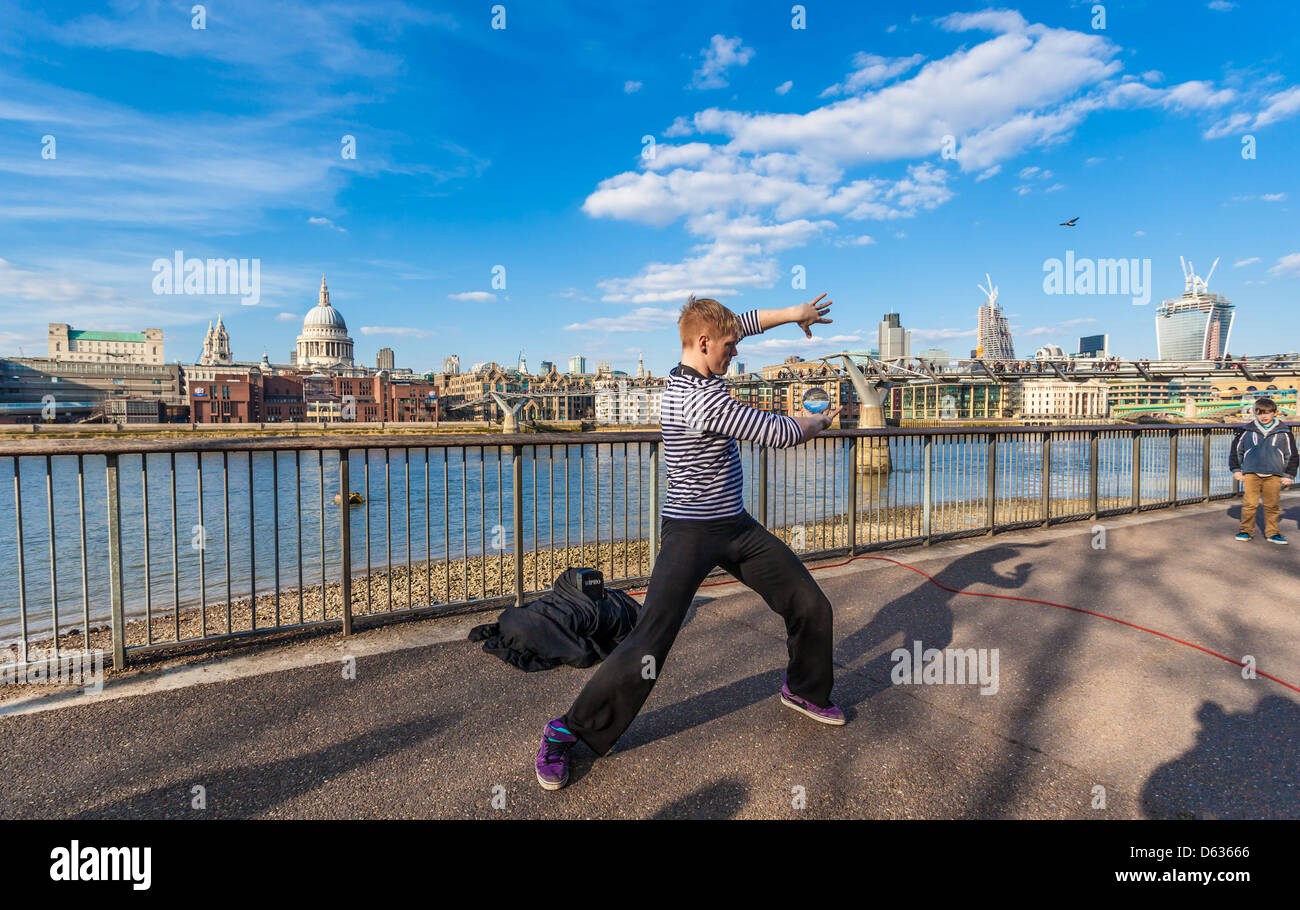 Street performer juggling with a crystal ball on The River Thames ...