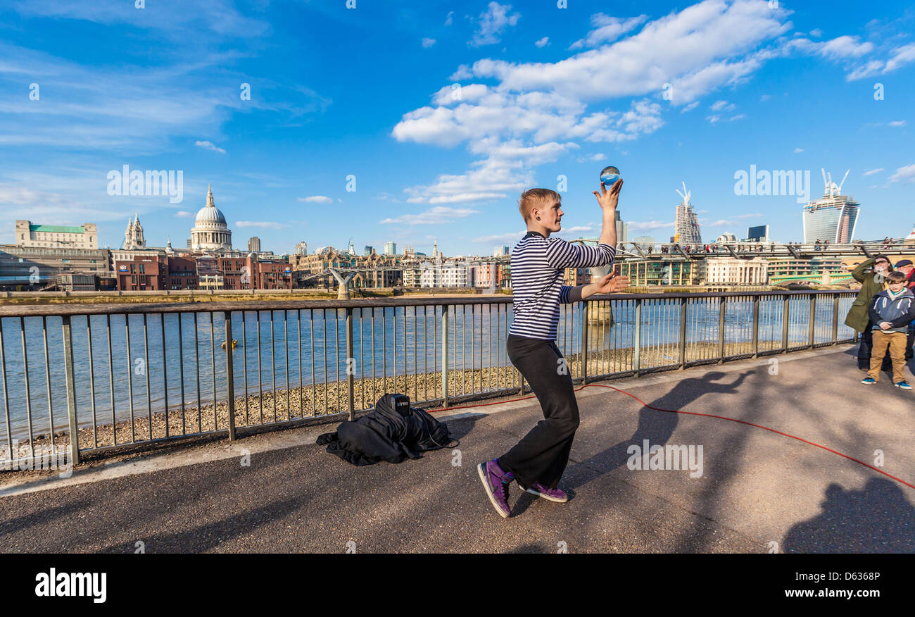 Street performer juggling with a crystal ball on The River Thames ...