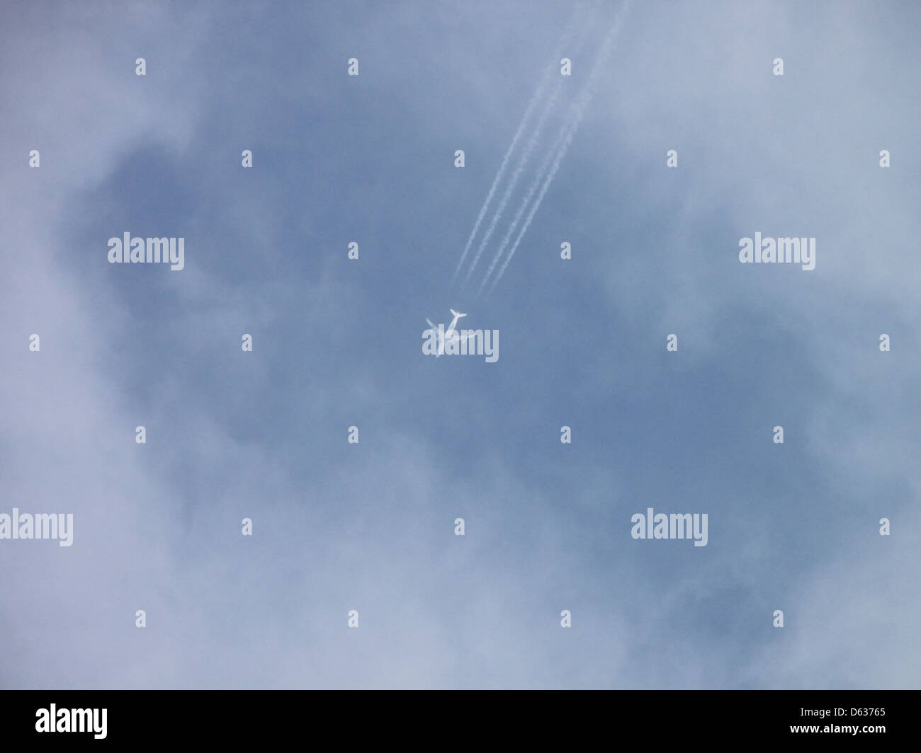 An airplane flying through the sky, leaving a jet stream behind against ...