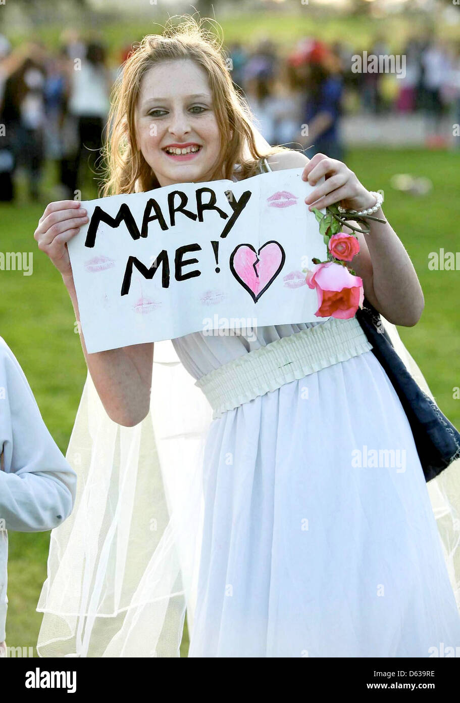 Atmosphere A fan dressed in a wedding dress with a sign 'Marry Me ...