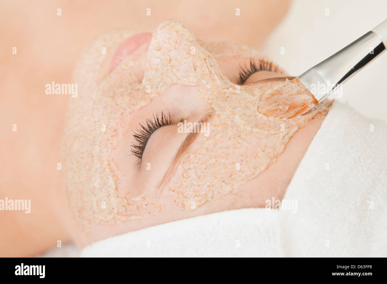 Close up of woman's face with beauty mask being applied, Studio shot ...