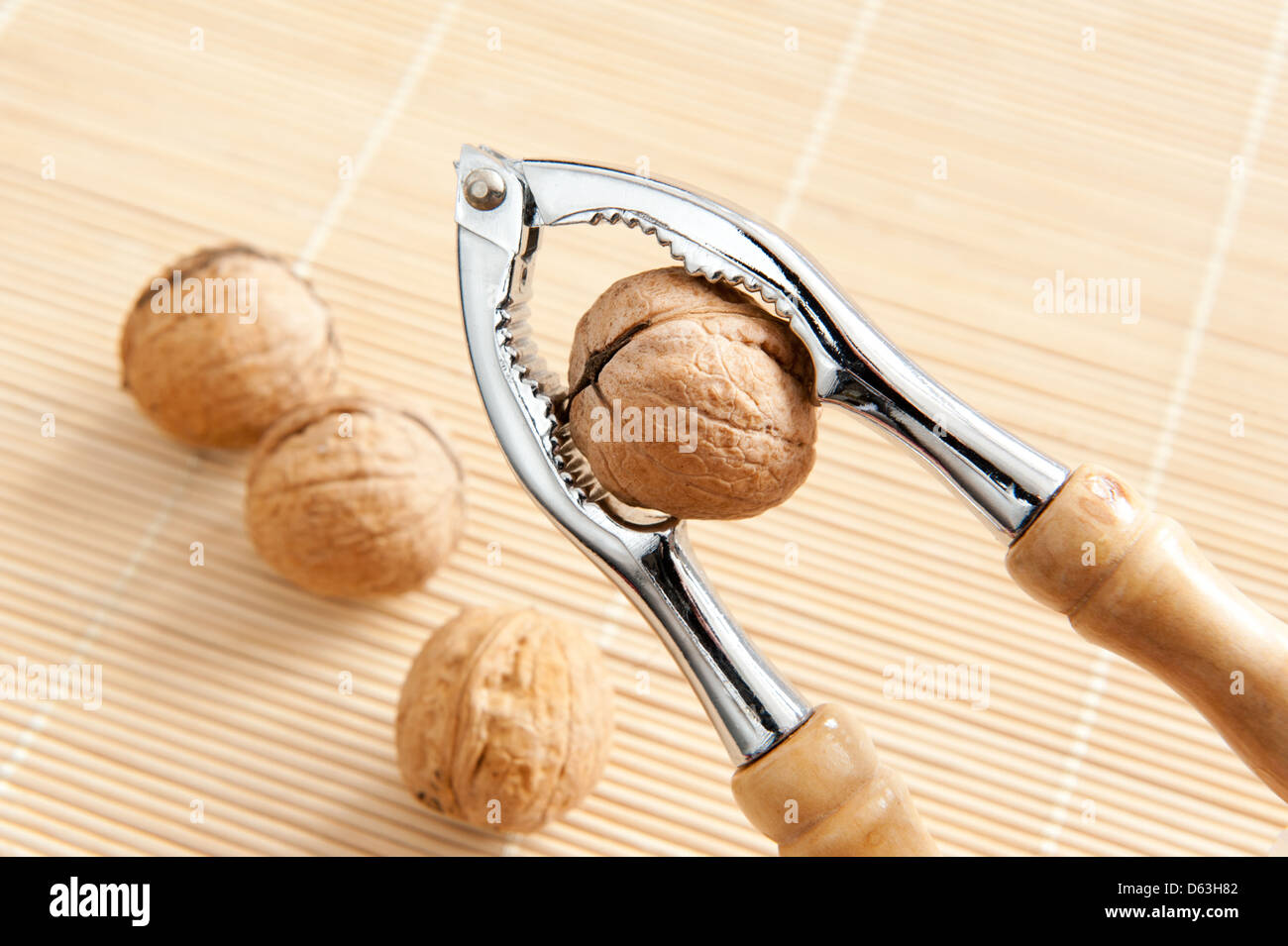 Walnut in shell in nutcracker and more walnuts Stock Photo - Alamy