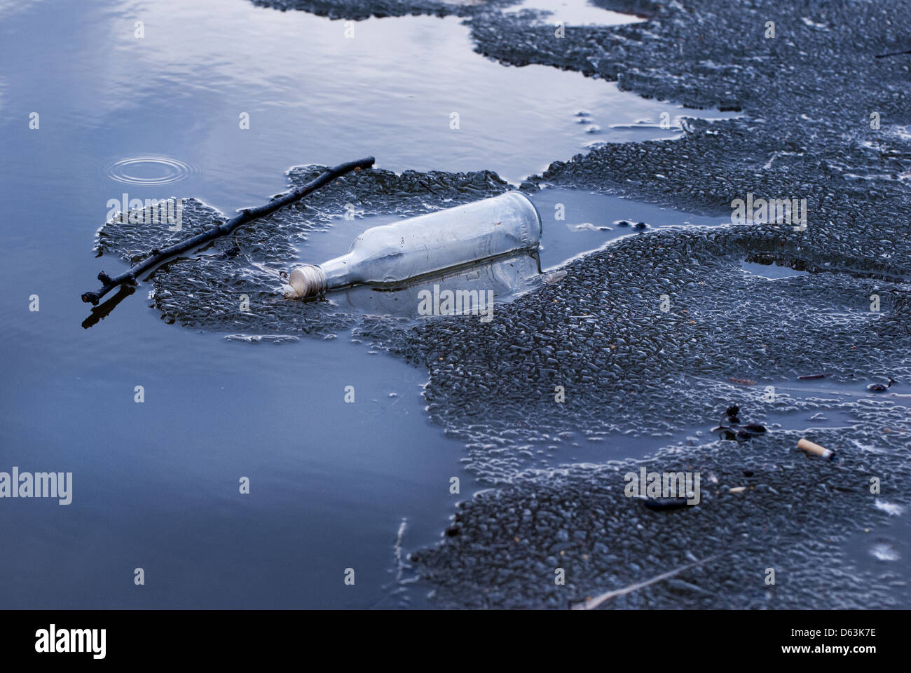 glass bottle garbage on melting ice on lake Stock Photo - Alamy