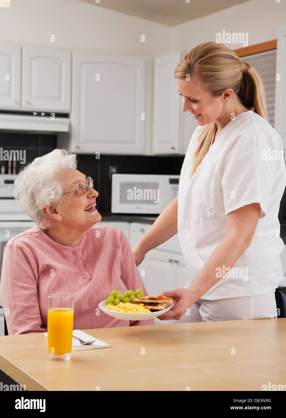 Nurse giving patient meal Stock Photo - Alamy