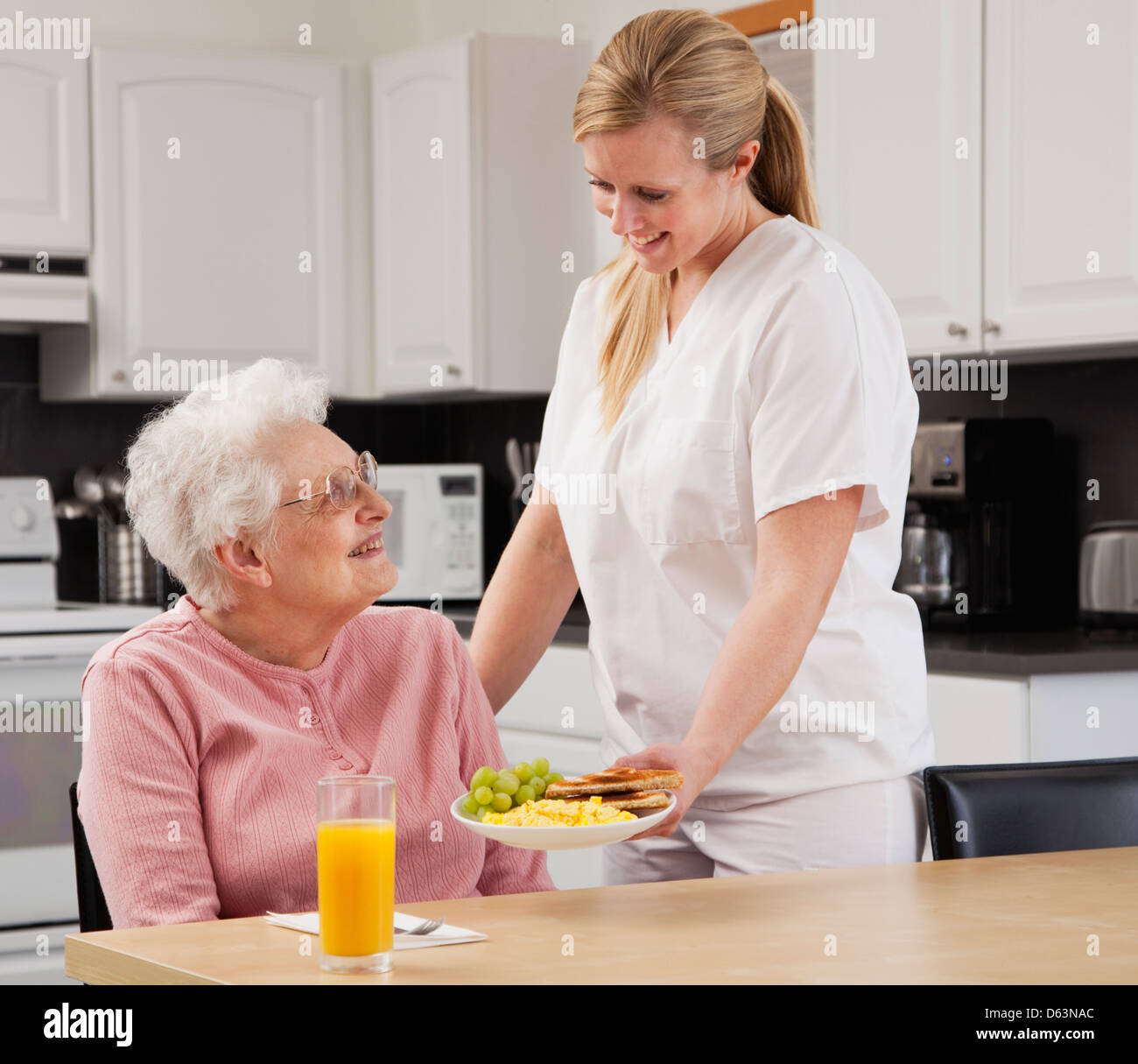 Nurse giving patient meal Stock Photo - Alamy