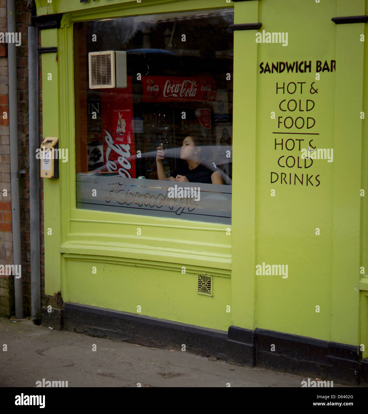 Woman sitting in a sandwich shop window on mobile phone Stock Photo - Alamy