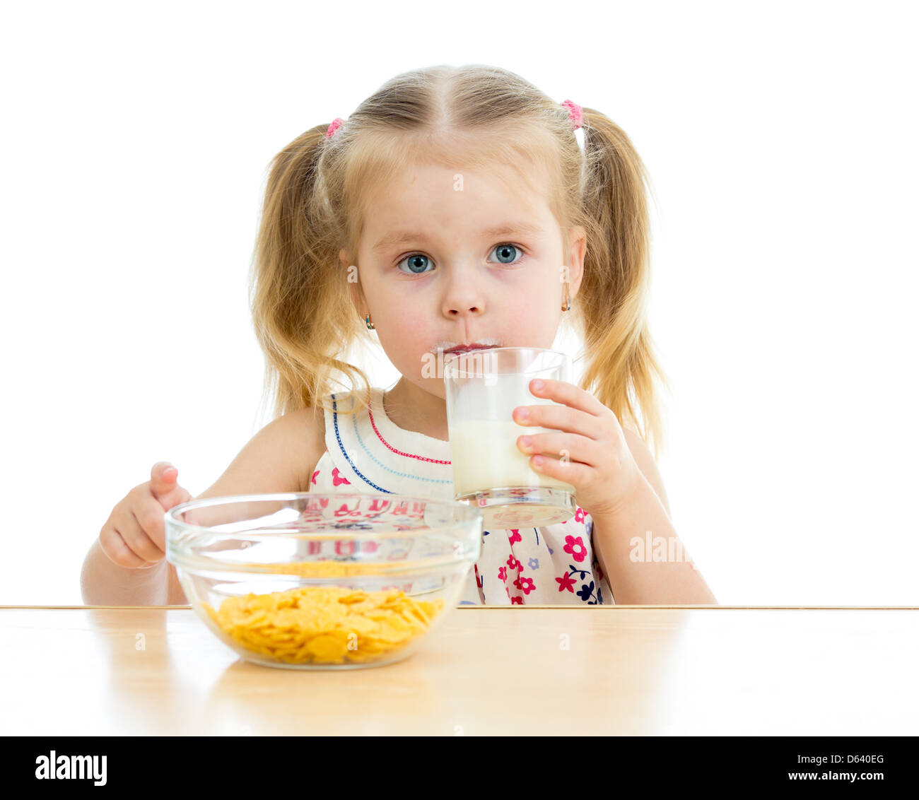 kid girl eating corn flakes with milk over white Stock Photo - Alamy