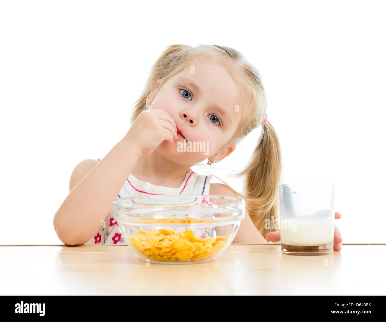 kid girl eating corn flakes with milk over white Stock Photo - Alamy