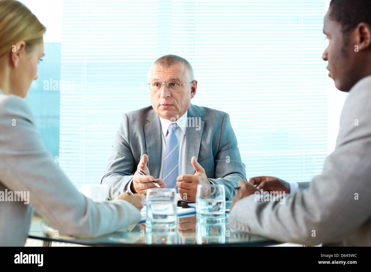 Portrait of serious boss interacting with his employees Stock Photo - Alamy