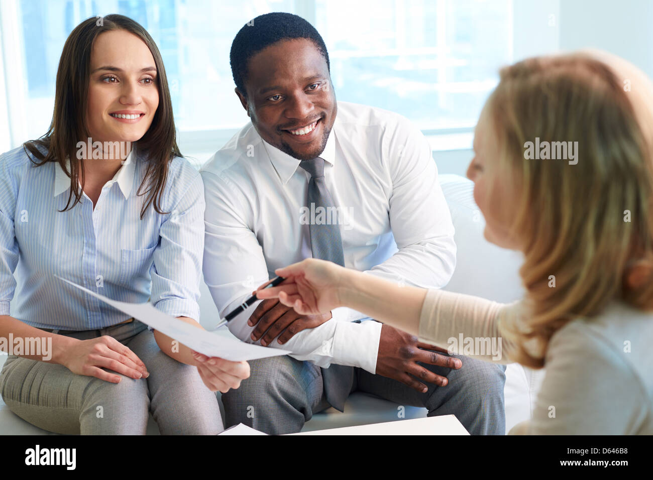 Image of confident colleagues looking at their business partner ...