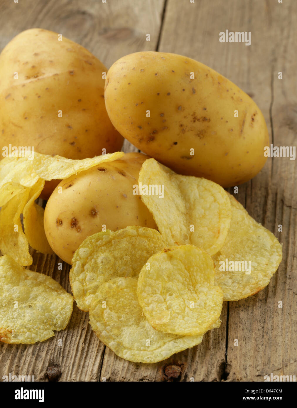 natural potato chips and fresh potato on a wooden background Stock ...