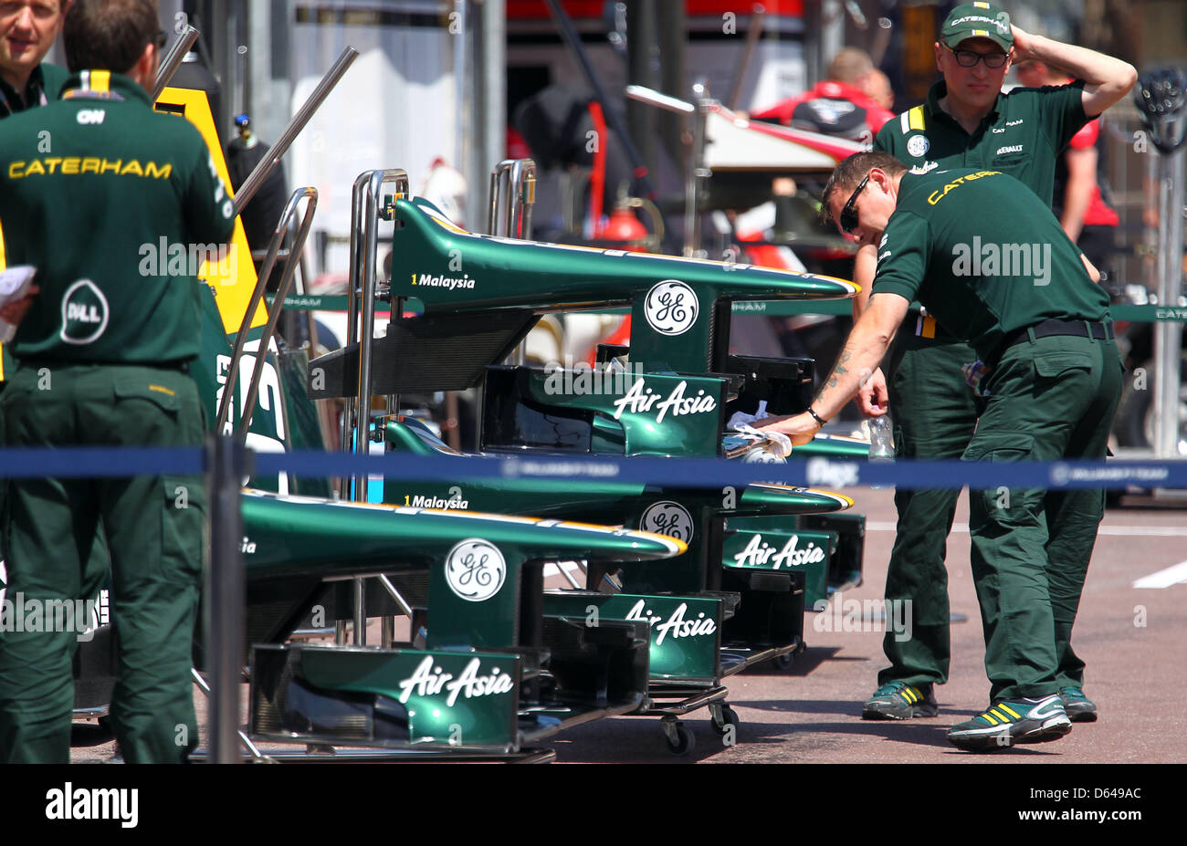 Mechanics of Caterham prepares in front of the teamgarage at the F1 ...