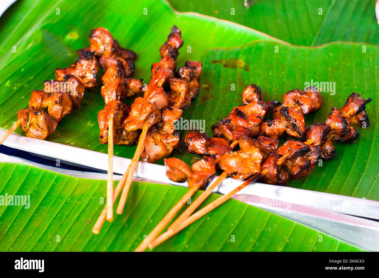 Traditional Thai food at market. Delicious spicy grilled chicken fillet ...