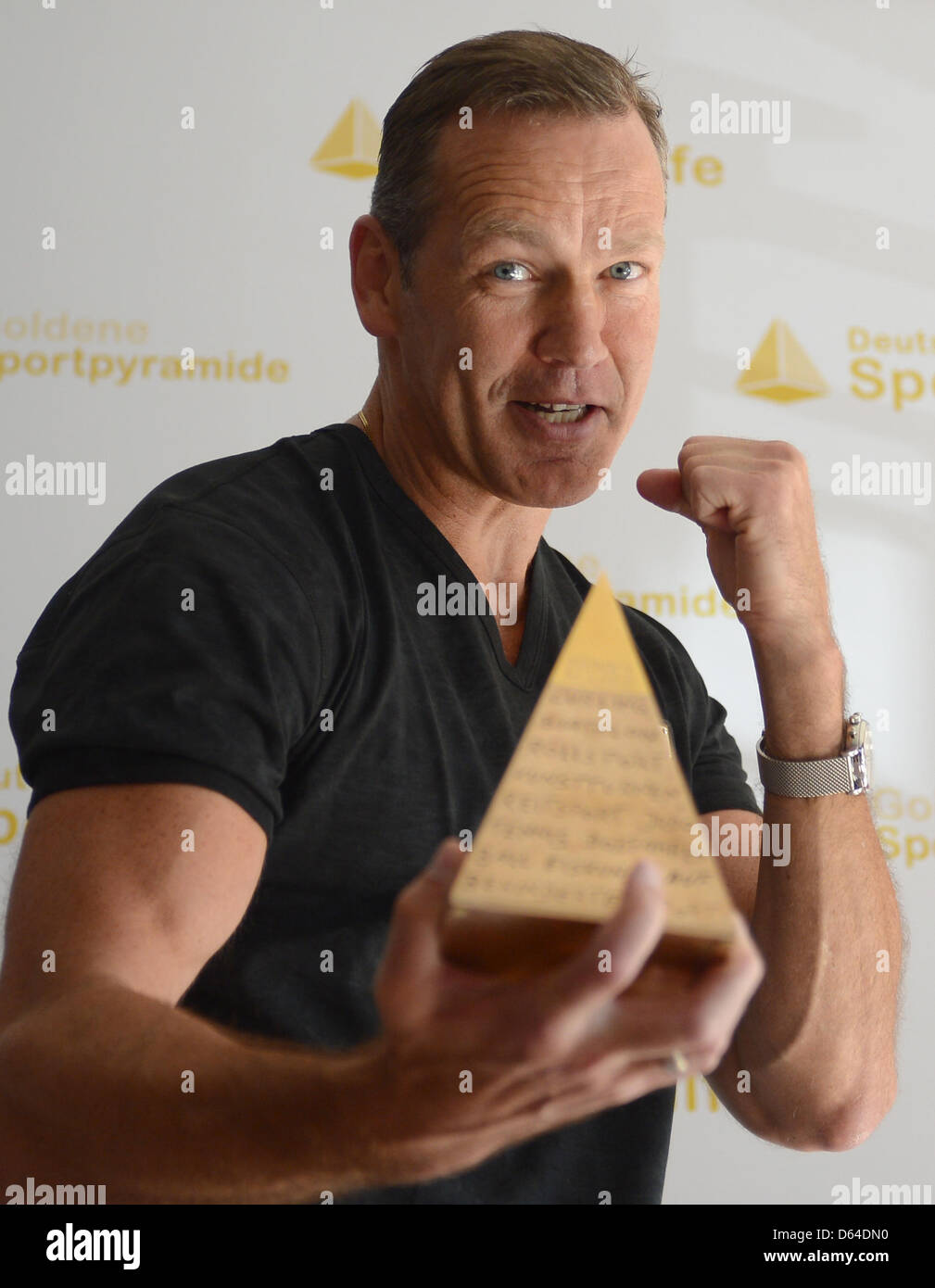 Former boxer Henry Maske holds the "Golden Sport Pyramid" during the ...