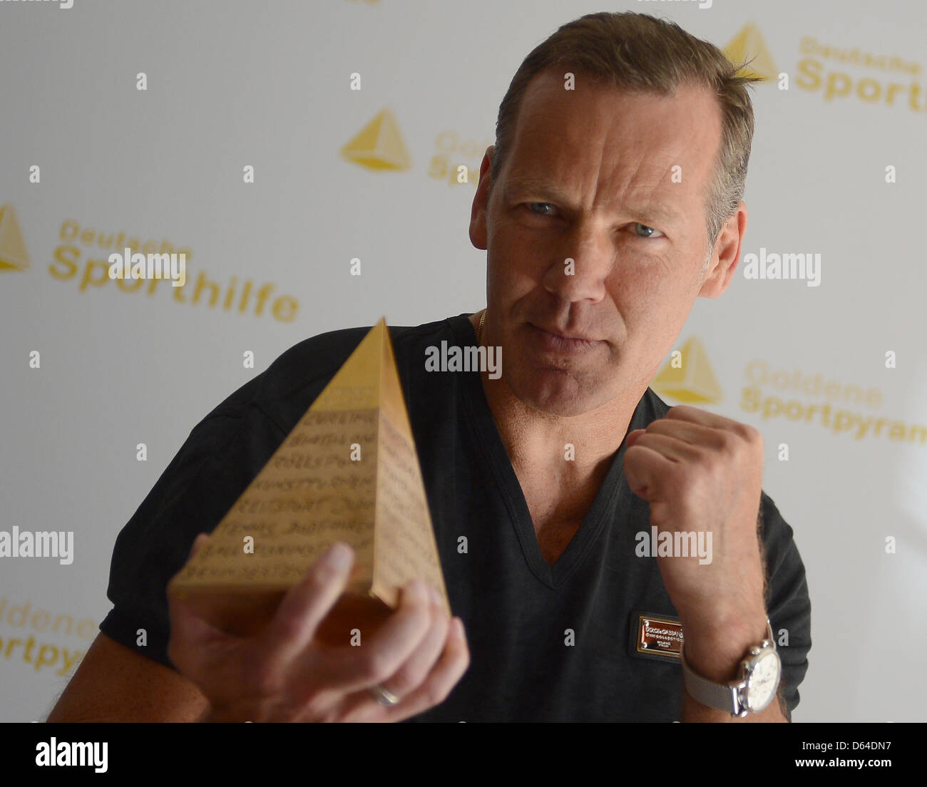 Former boxer Henry Maske holds the "Golden Sport Pyramid" during the ...