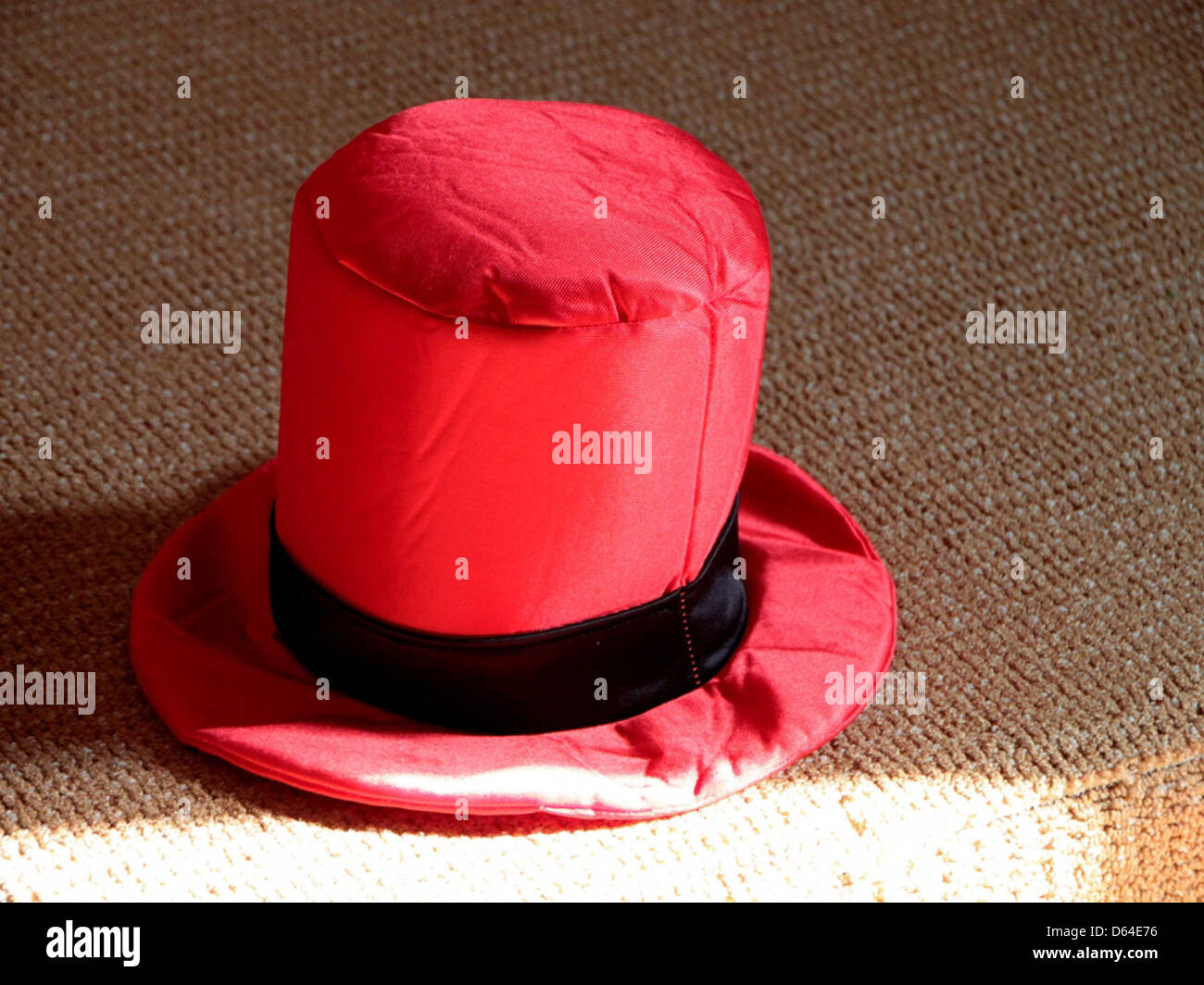 A bright red clown hat, commonly associated with circus performances ...