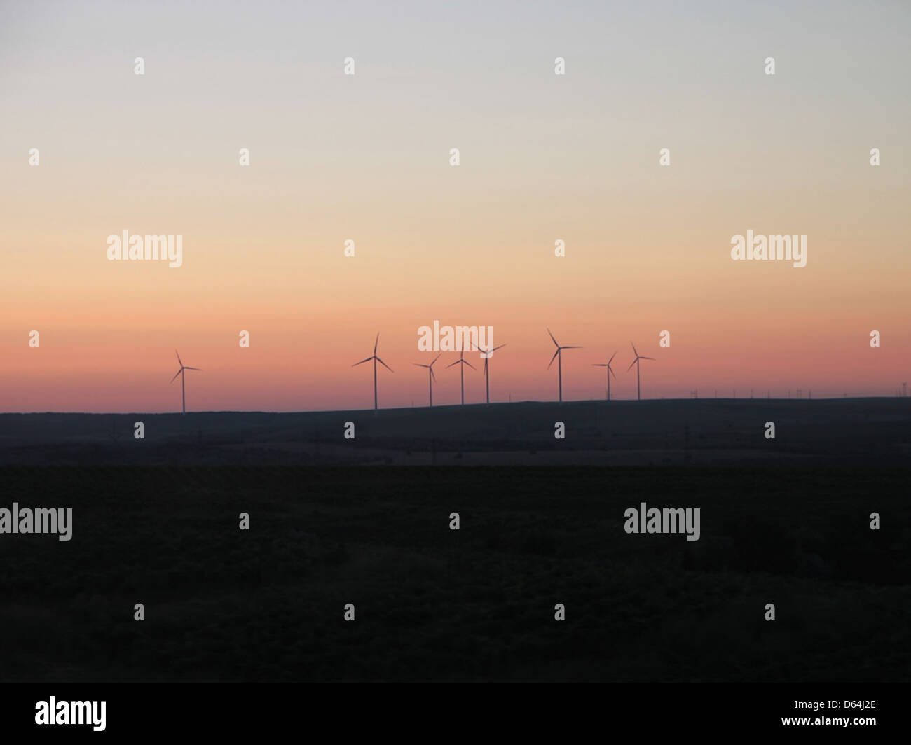 A wind farm situated on the horizon, with multiple wind turbines ...