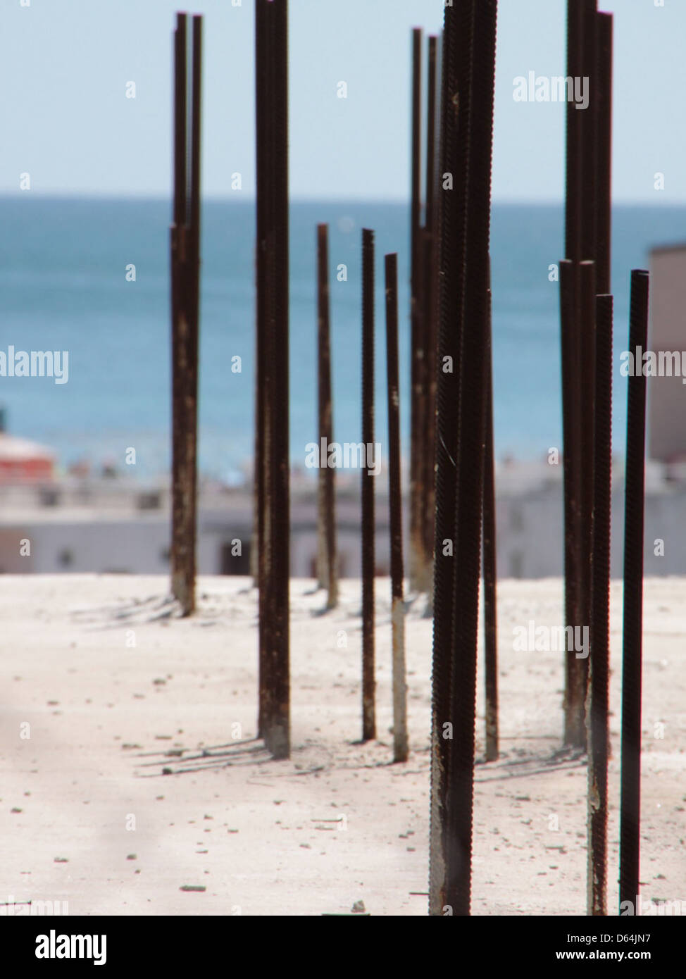 A photograph showing rusty iron bars embedded in concrete, highlighting ...