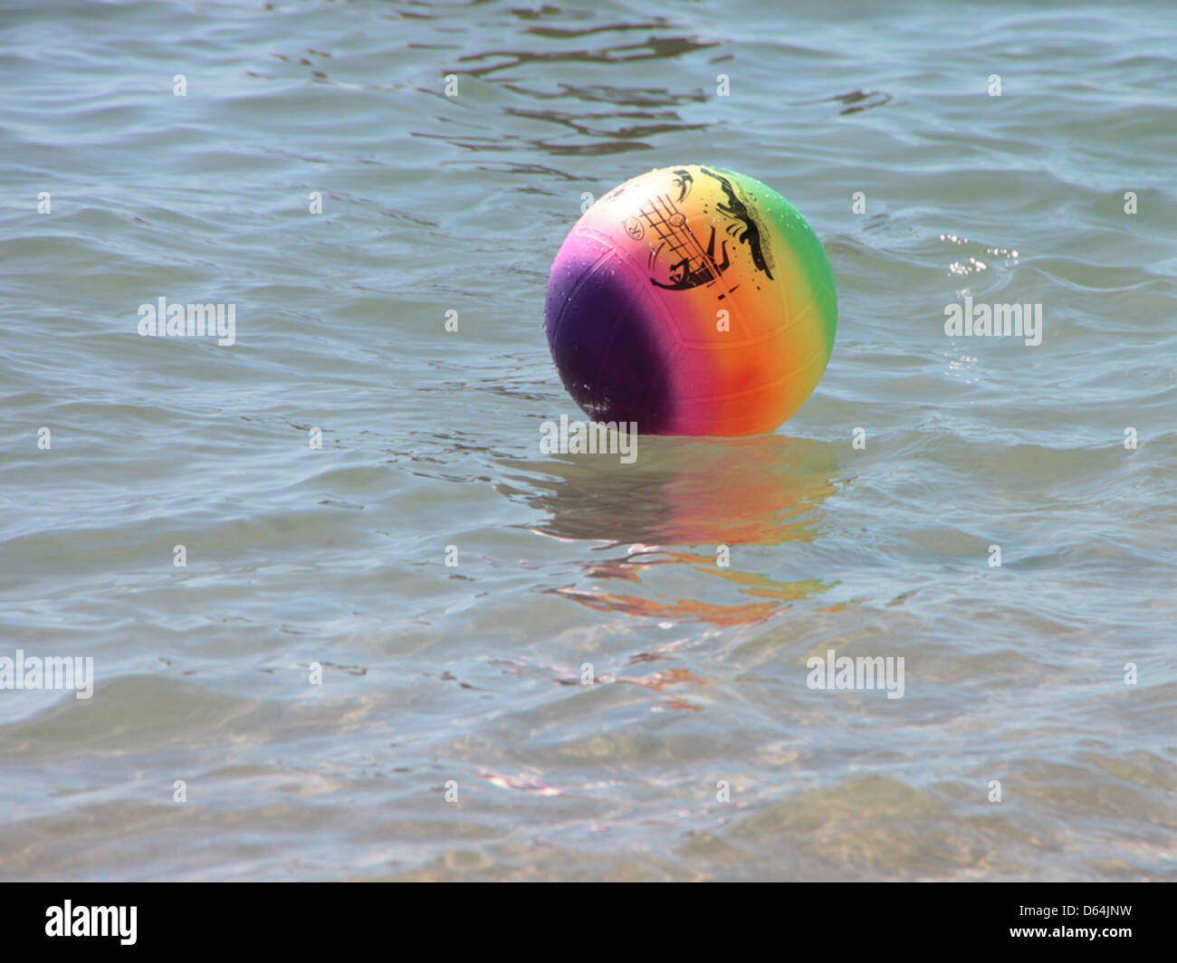 This image captures a soccer ball floating in water, surrounded by ...