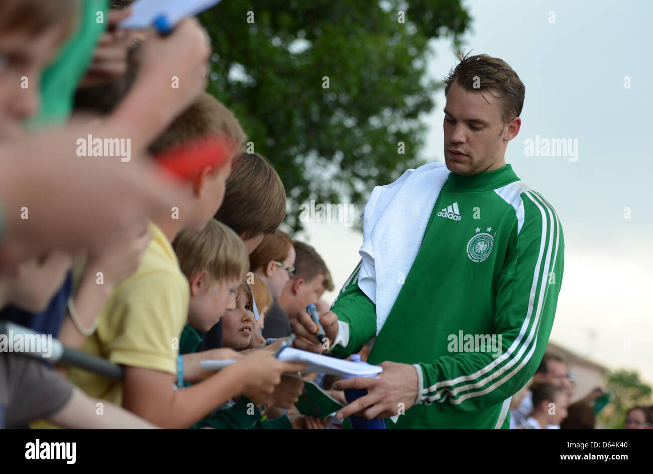 Germany's goalkeeper Manuel Neuer (R) signs autographs after practice ...