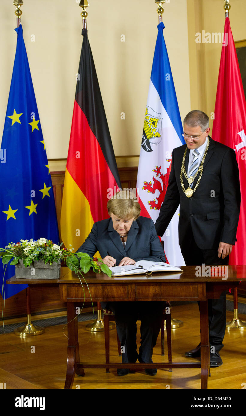 German chancellor Angela Merkel signs the golden book at the city hall ...