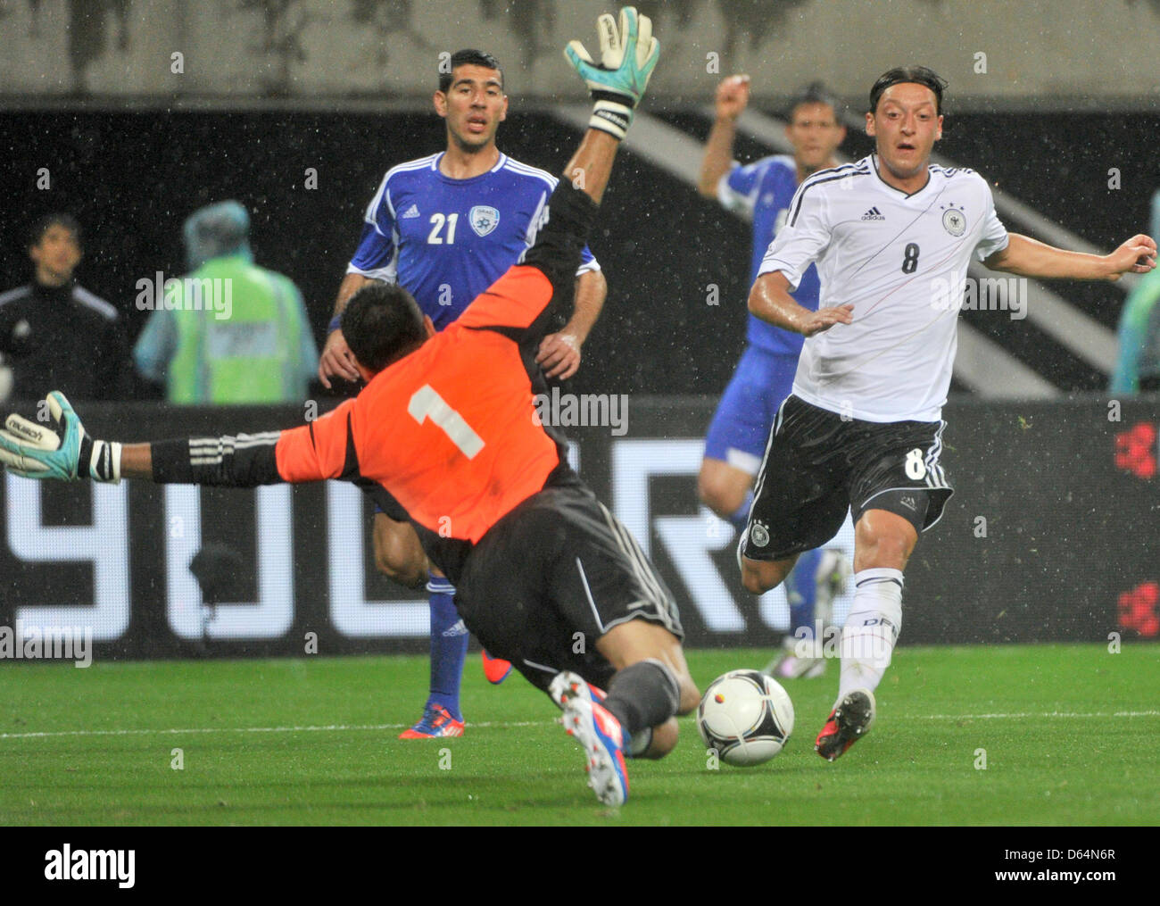Germany's Mesut Oezil (R) and Israel's goalkeeper Ariel Harush (L) vie ...