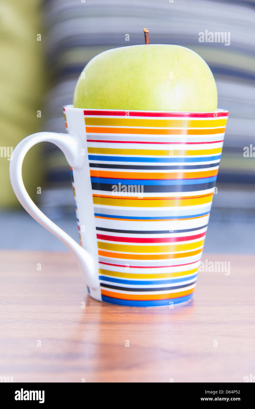 Apple in a cup Stock Photo - Alamy