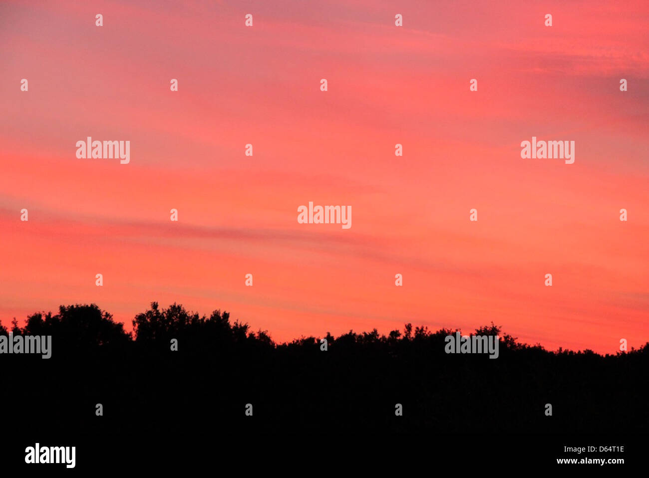 The image shows vibrant red clouds in the sky, likely during a sunset ...
