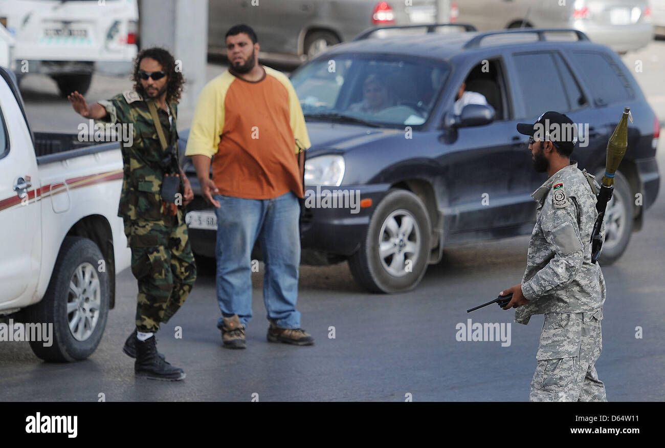 Militiamen have set up a checkpoint on a road to the airport and check ...