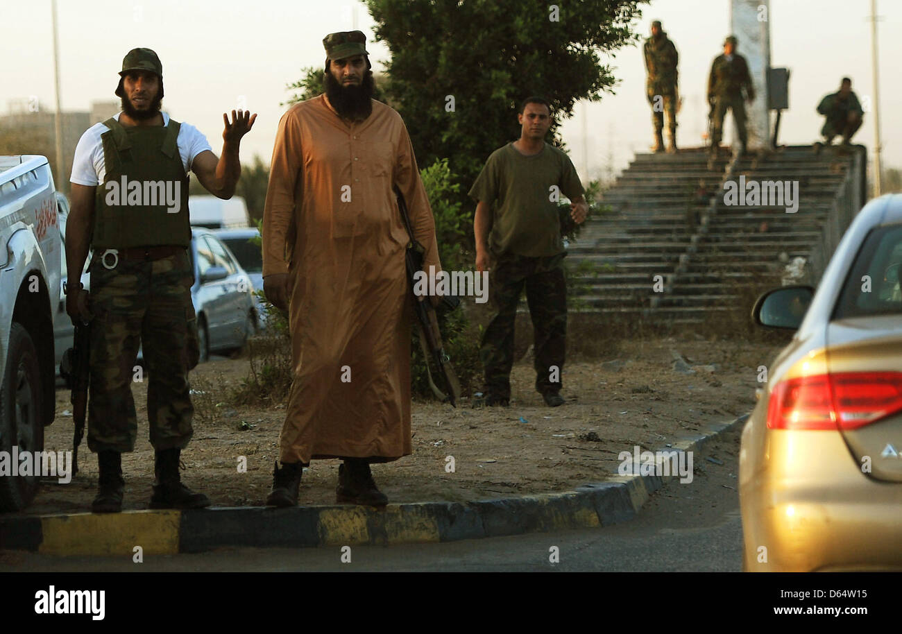 Militiamen have set up a checkpoint on a road to the airport and check ...