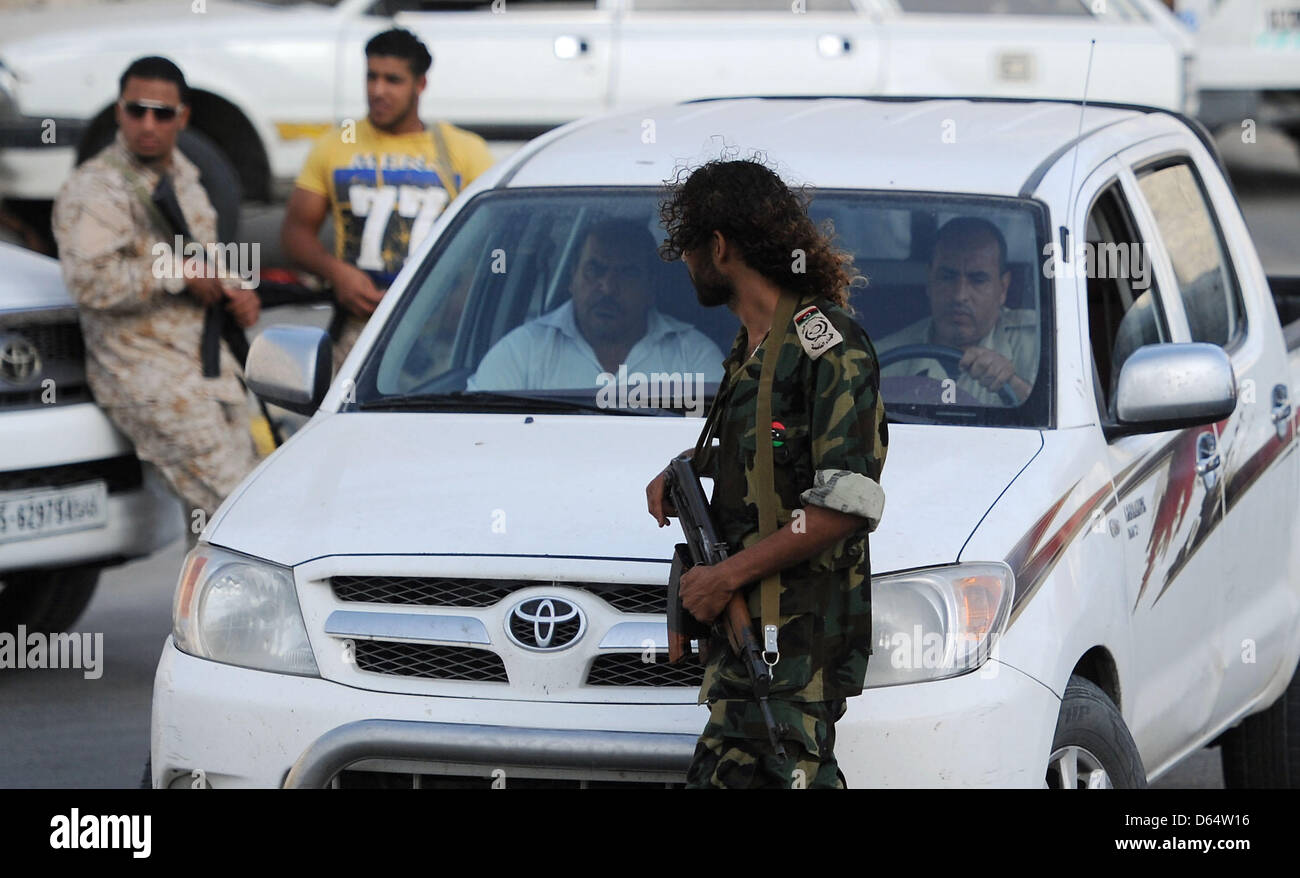 Militiamen have set up a checkpoint on a road to the airport and check ...