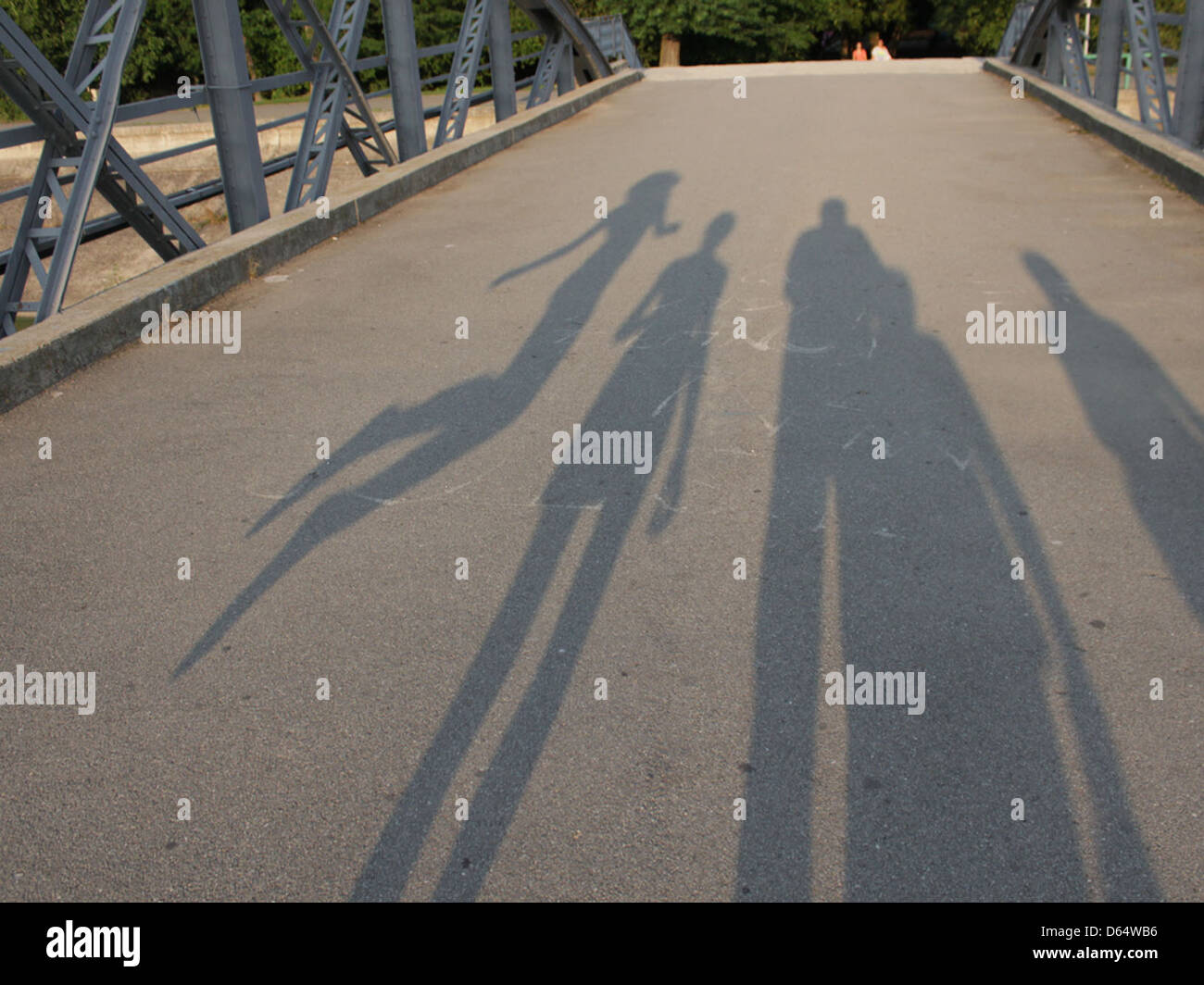 A dramatic silhouette photo of five people casting long shadows on the ...