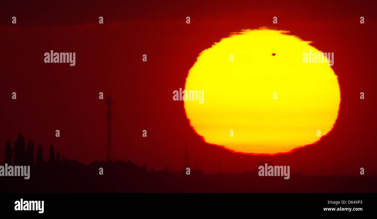 Planet Venues passes by in front of the yellow disk of the rising sun ...
