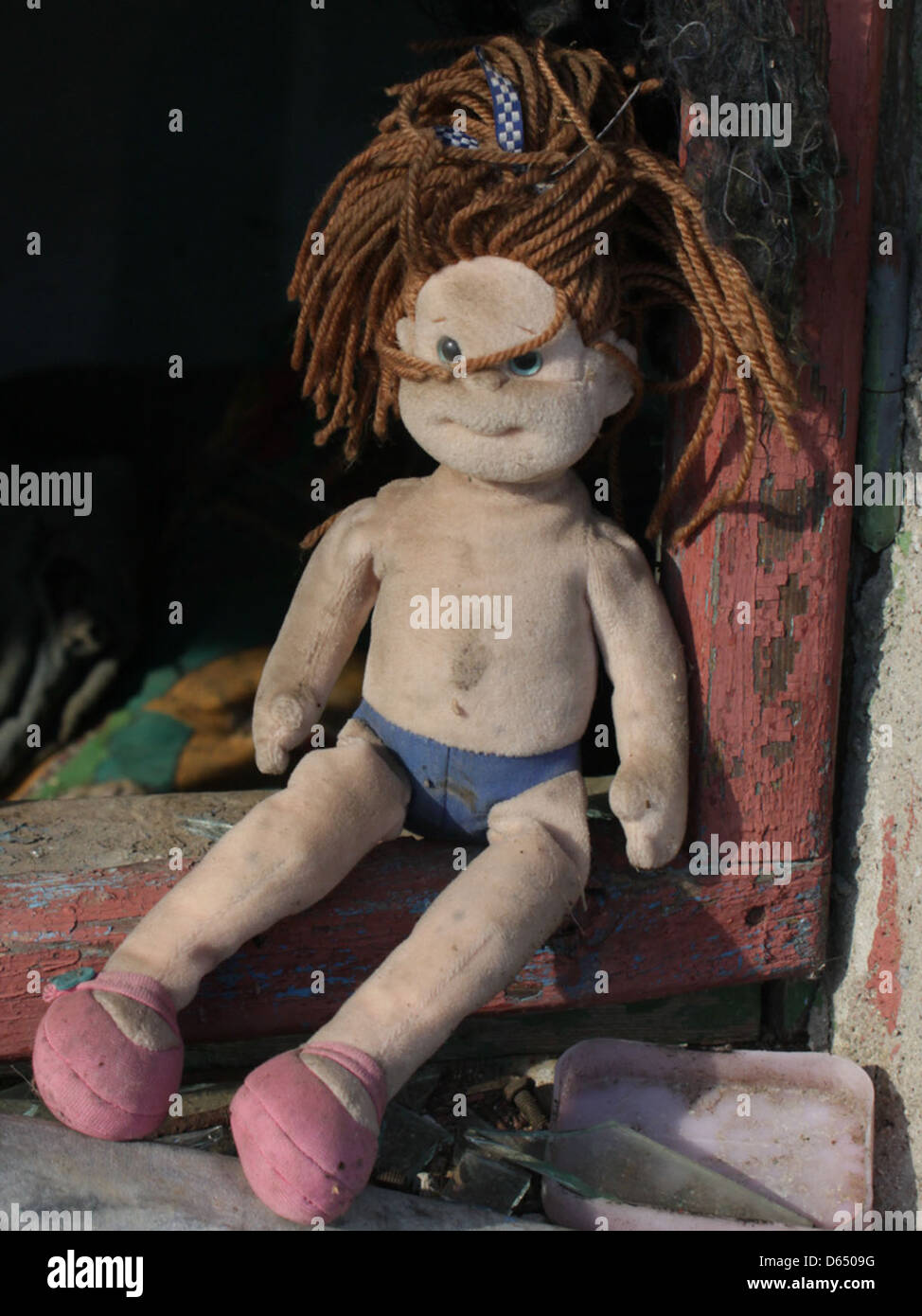 A photo of an old, abandoned doll showing wear and tear. The doll's ...