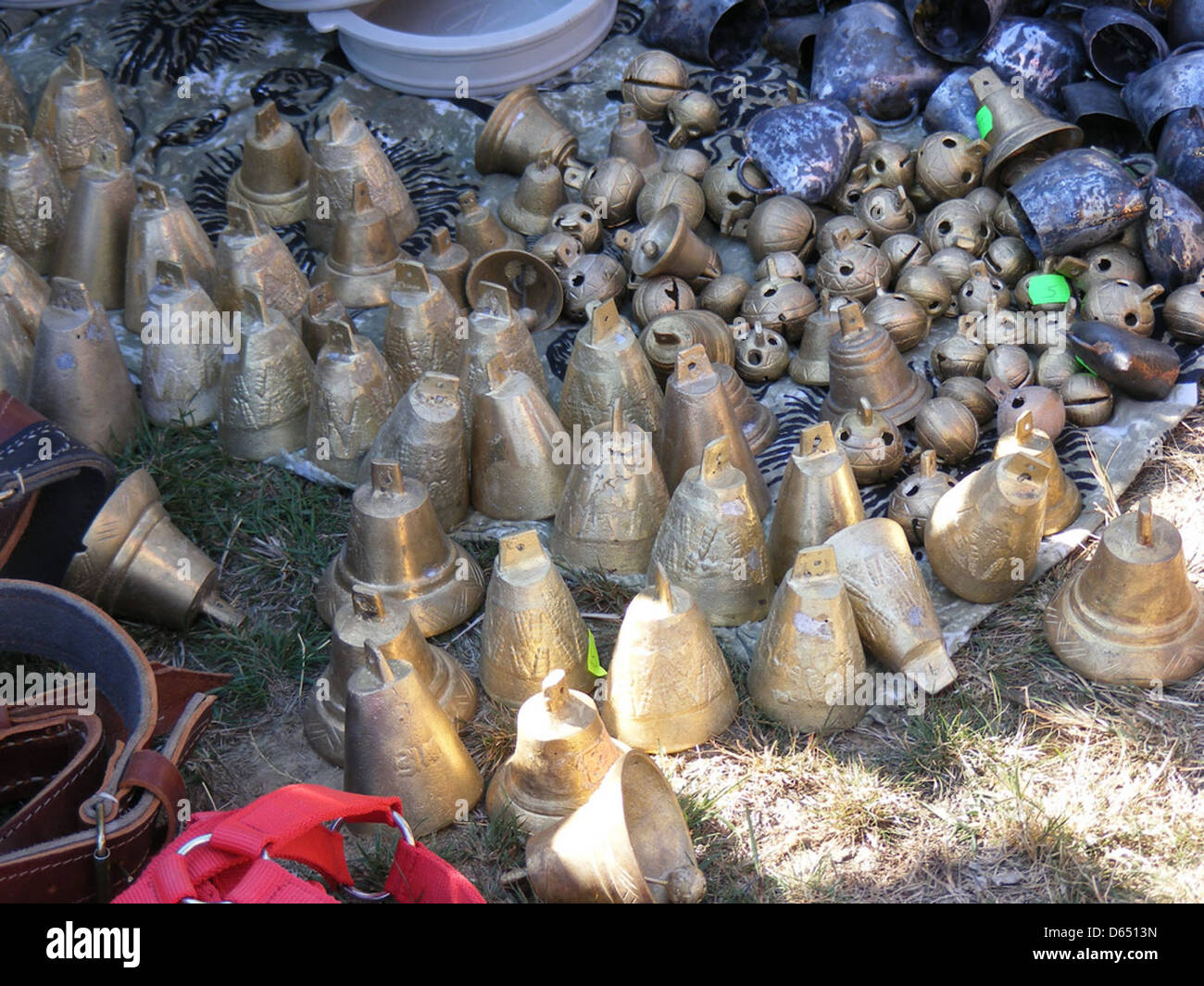 A collection of brass and iron bells designed for farm animals, often ...