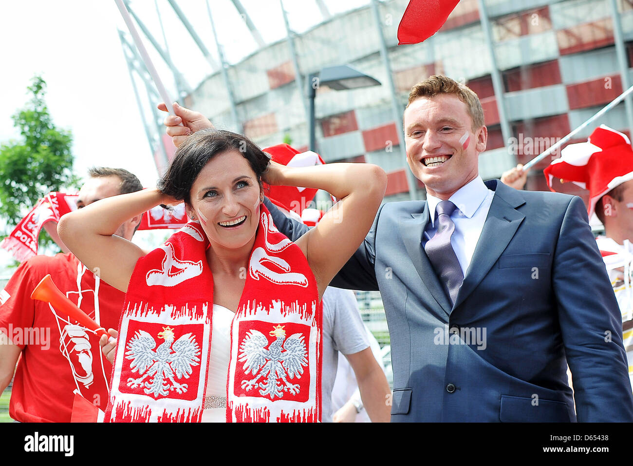 A Polish bridal couple stand in front of the national stadium in Warsaw ...