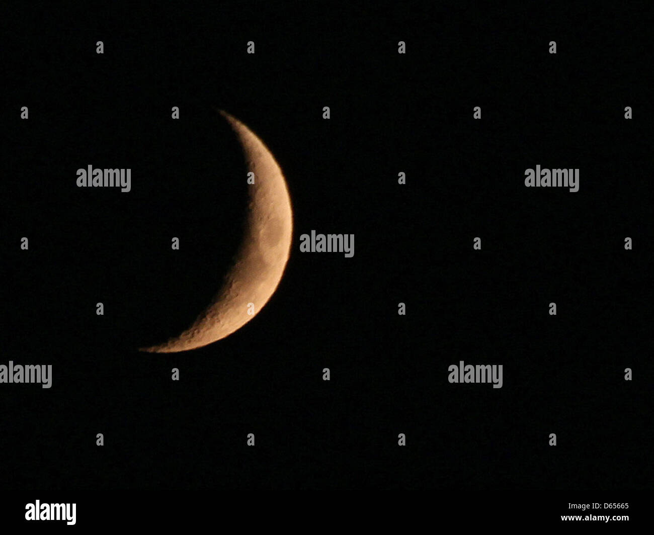 A waxing crescent moon in the dark night sky, capturing the phase of ...