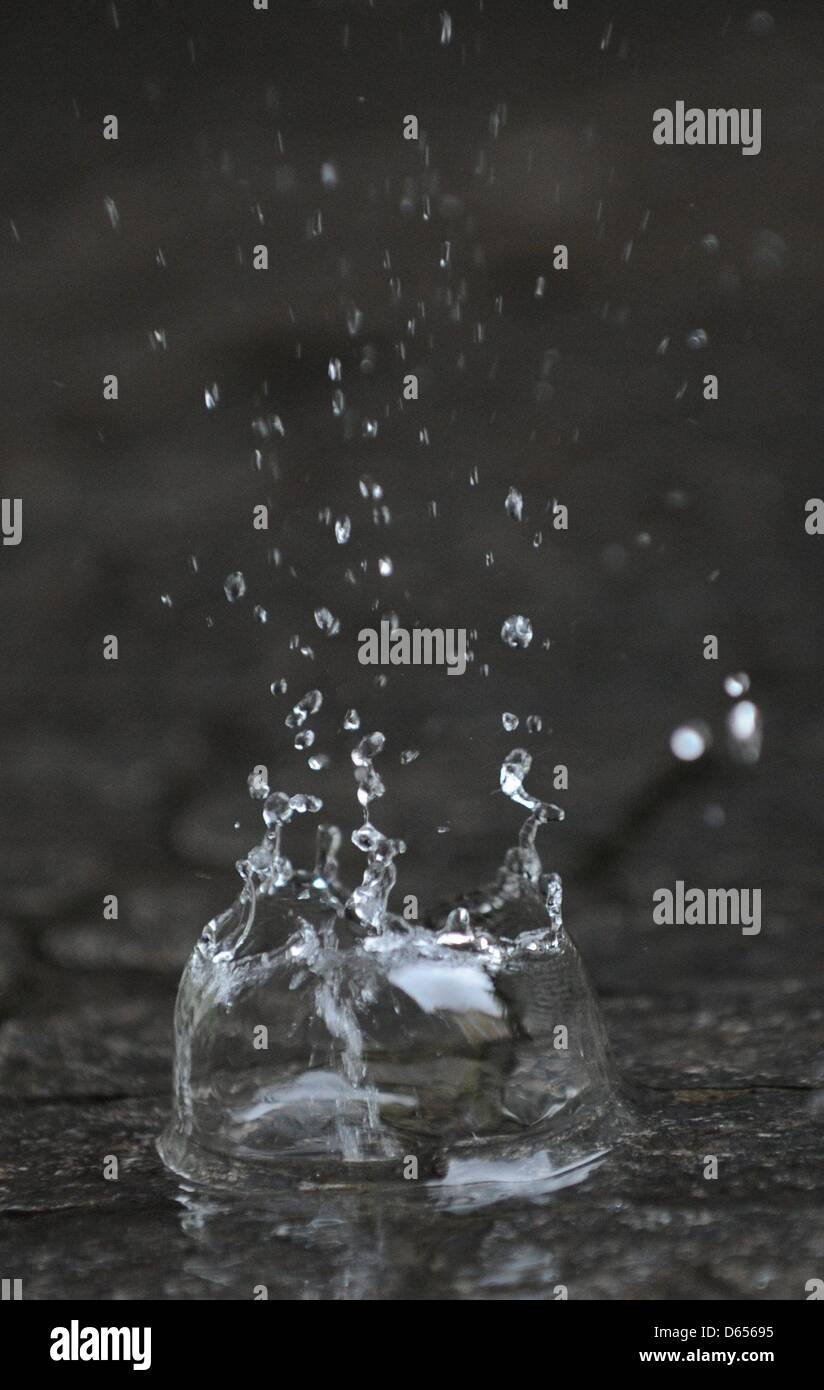 A raindrop falls into a puddle in Freiburg, Germany, 12 June 2012 ...