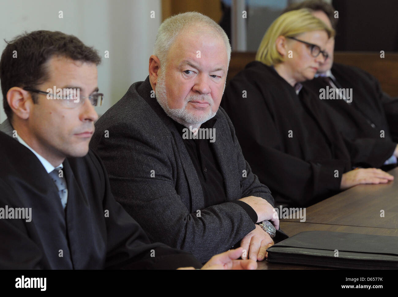 A court bailiff shows hotelier Axel Hilpert (C) sits with his lawyers ...