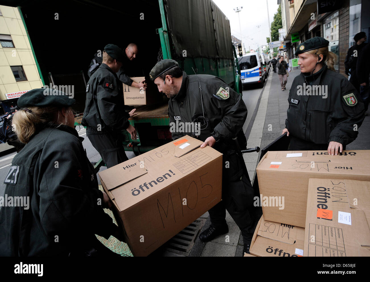 Police carry boxes of confiscated material out of the 'Millatu Ibrahim ...